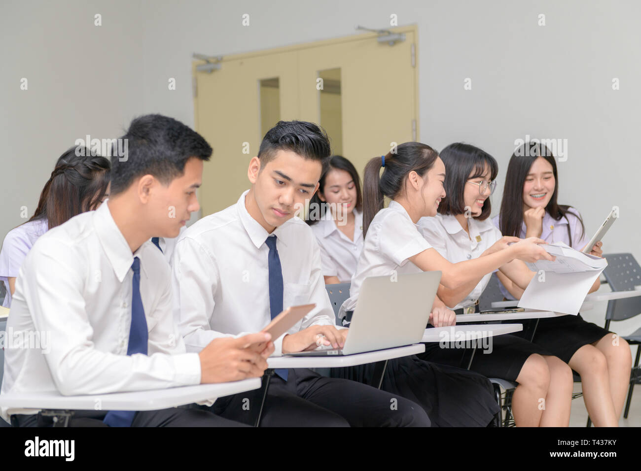 Teenage Students in uniform working with laptop in classroom at ...
