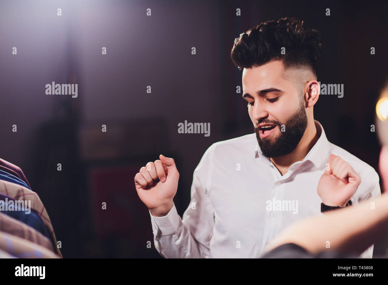 Male customer at shopping mall trying business clothes, shop assistant ...