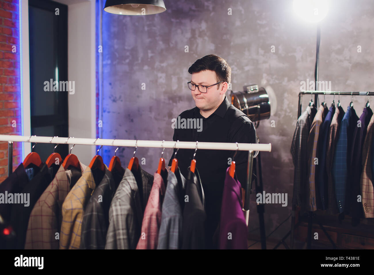 Male customer at shopping mall trying business clothes, shop assistant ...