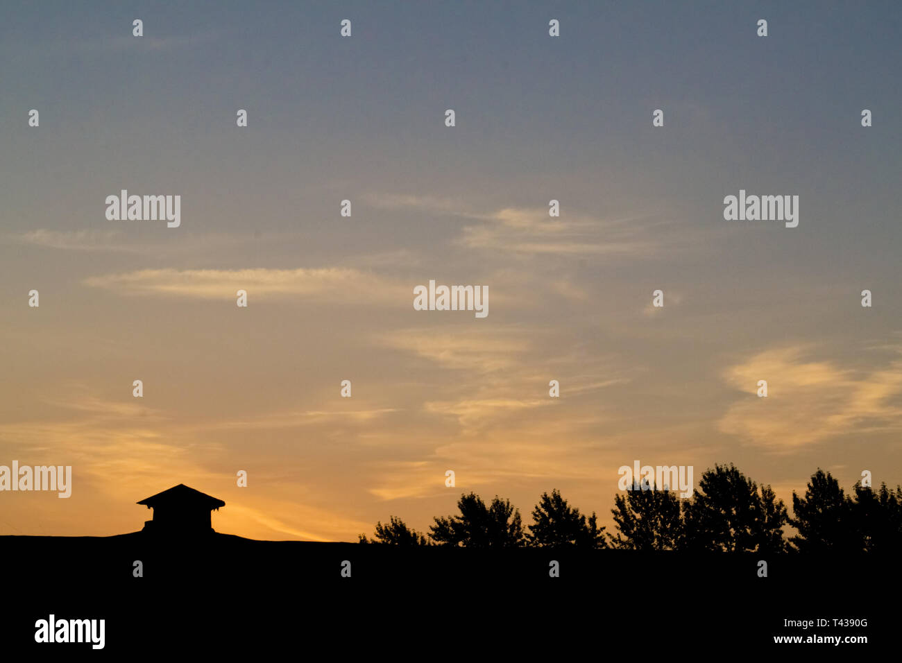 Dusk landscape. With fancy sunset sky and distant hut silhouette Stock ...