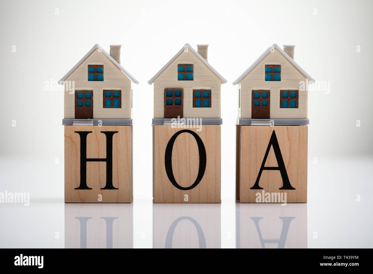 Row Of House Models On HOA Cubic Blocks Over Reflective Desk Stock ...