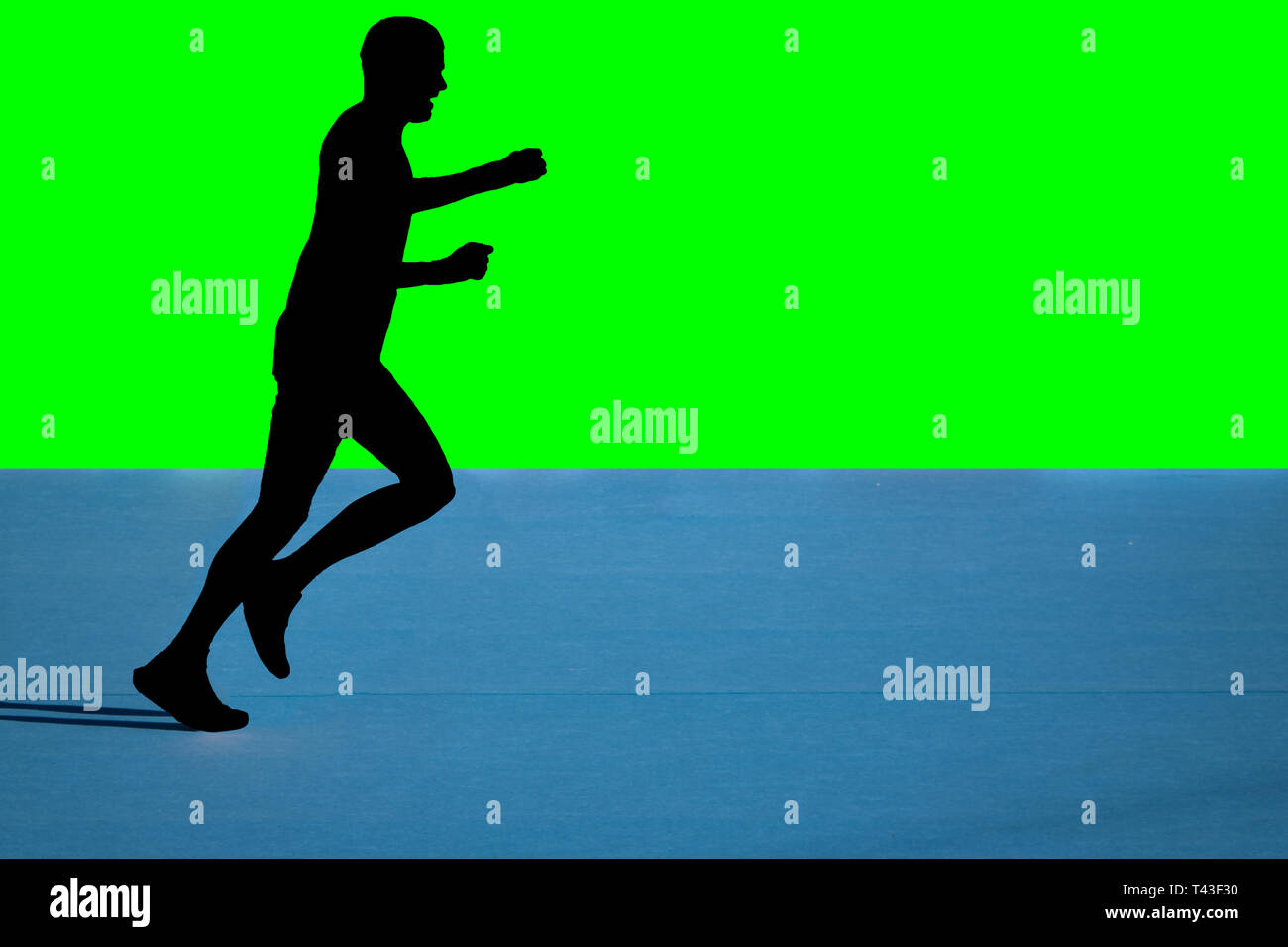 Fast marathon runner silhouette with green background Stock Photo - Alamy