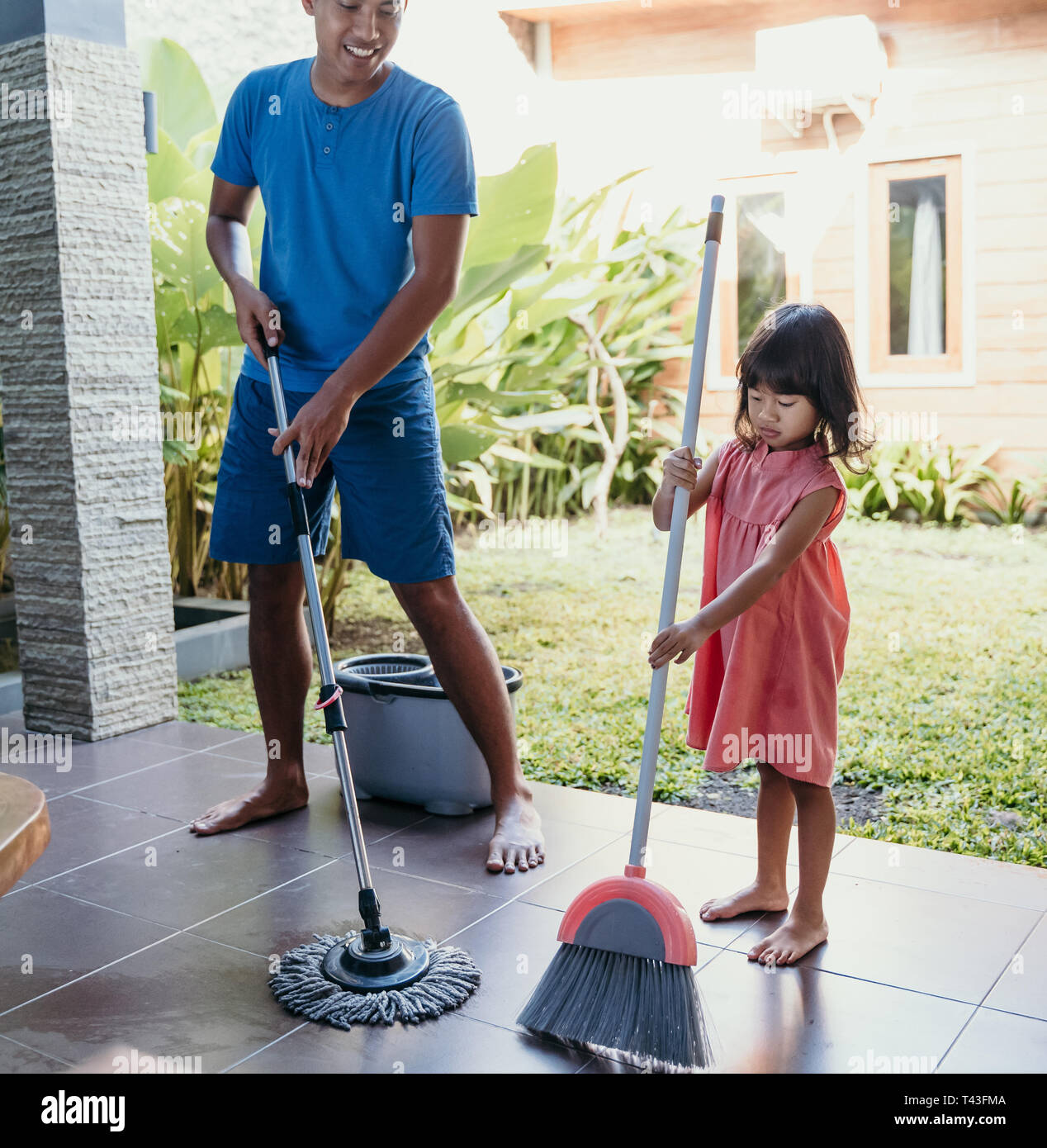 little girl help her daddy to do chores at home Stock Photo - Alamy