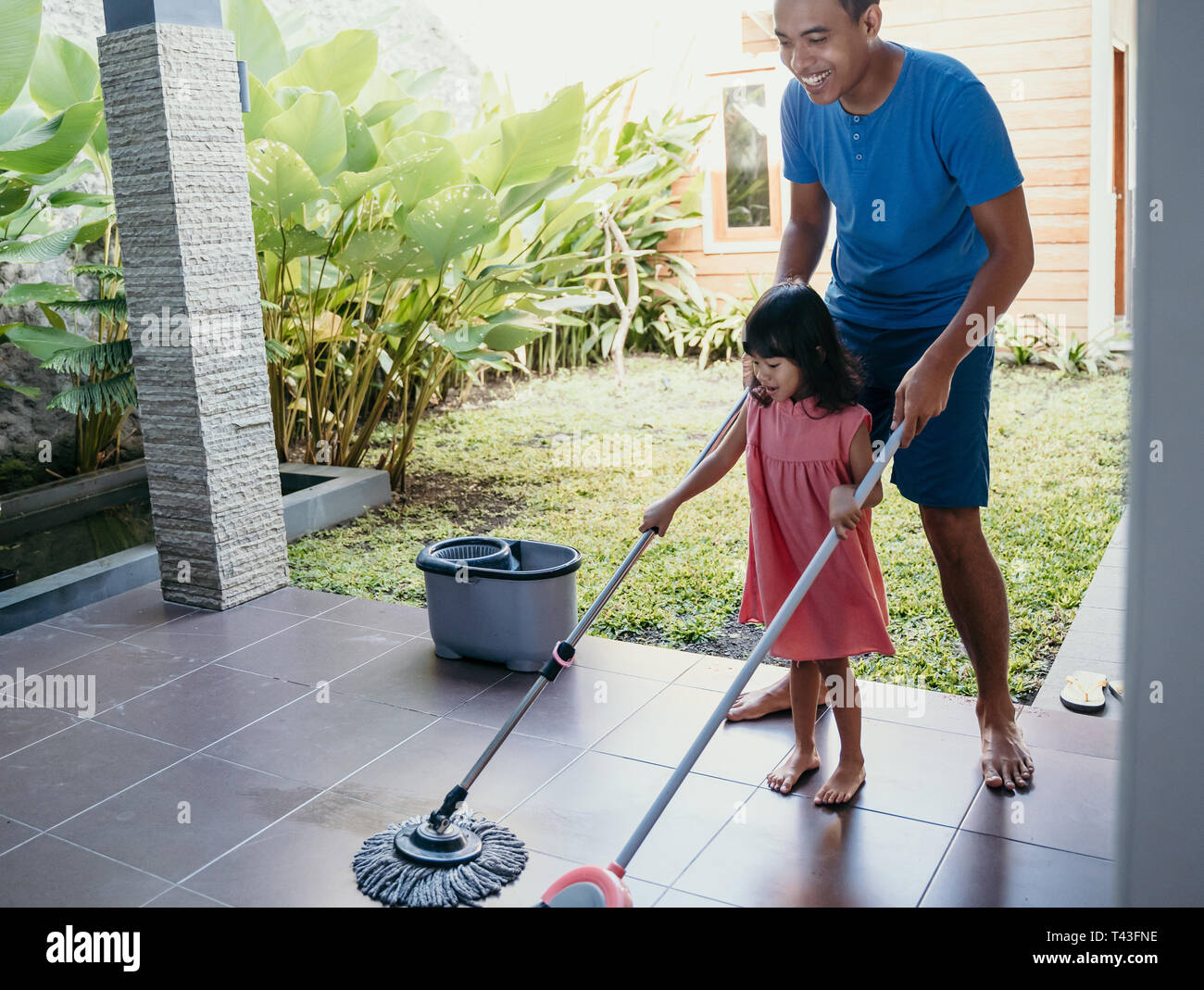 little girl help her daddy to do chores at home Stock Photo - Alamy