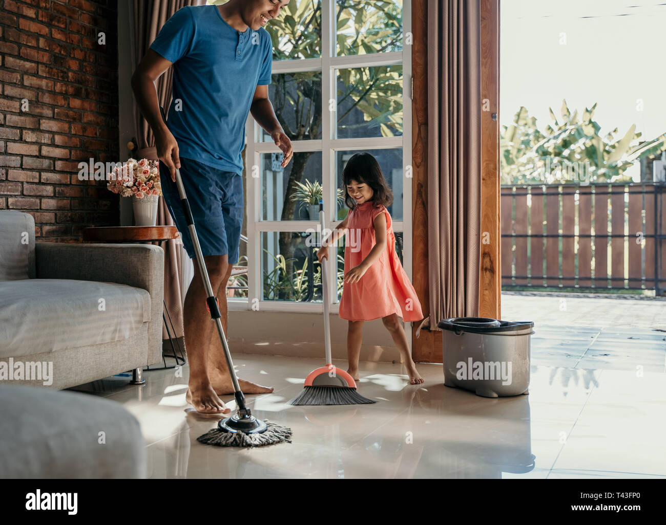 little girl help her daddy to do chores at home Stock Photo - Alamy