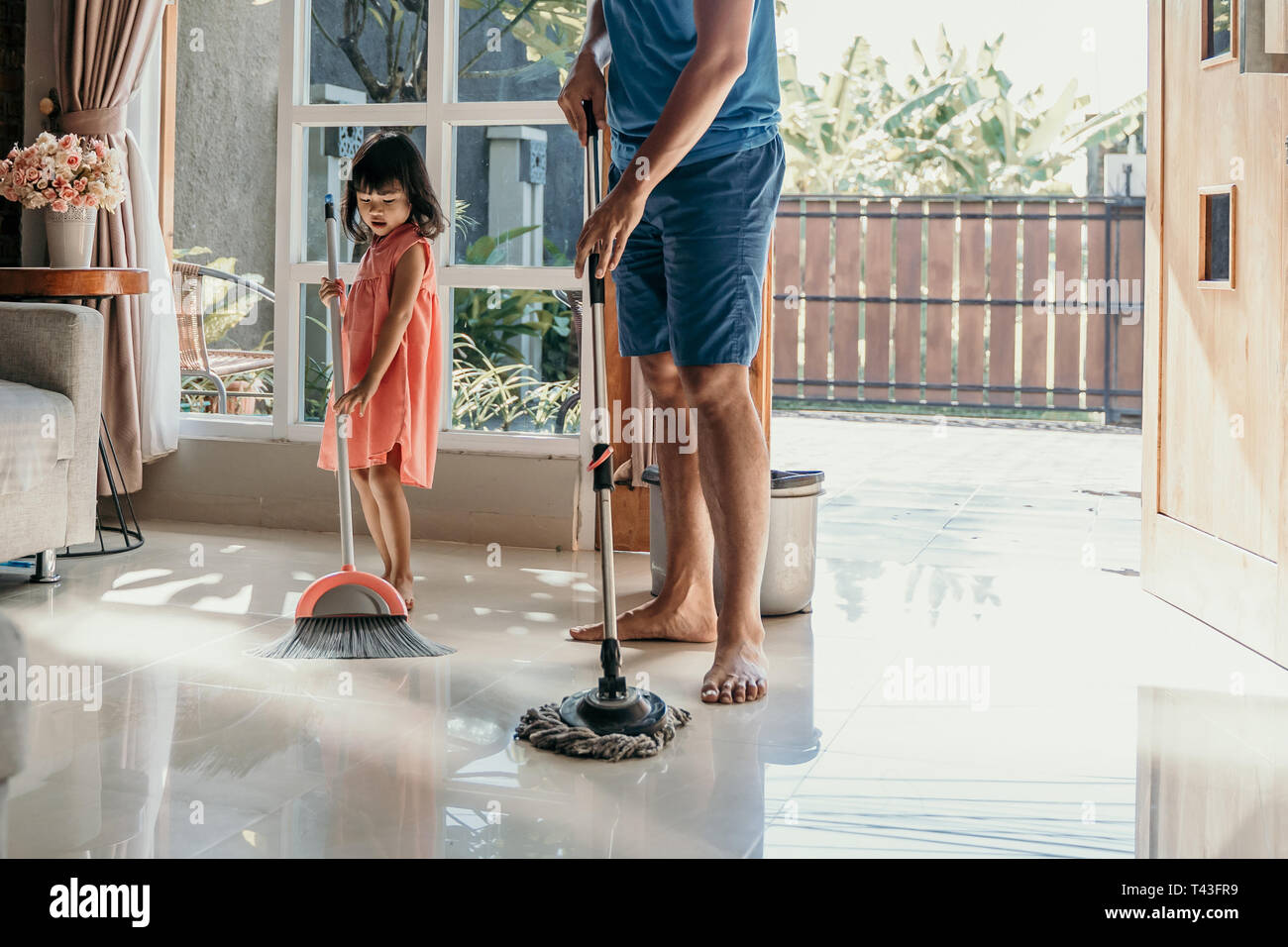 father and daughter clean up the house together sweep the floor Stock ...