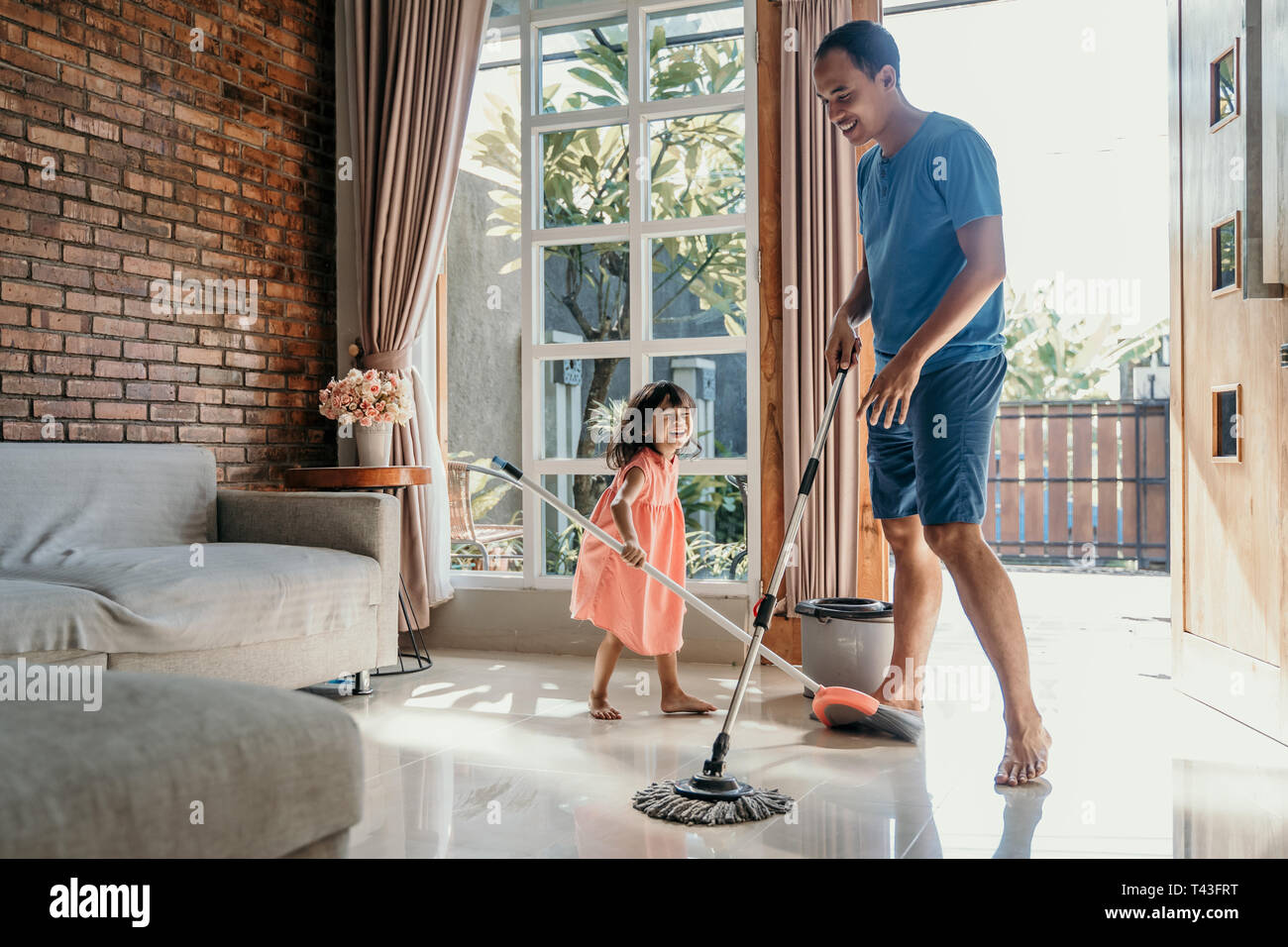 little girl help her daddy to do chores at home Stock Photo - Alamy
