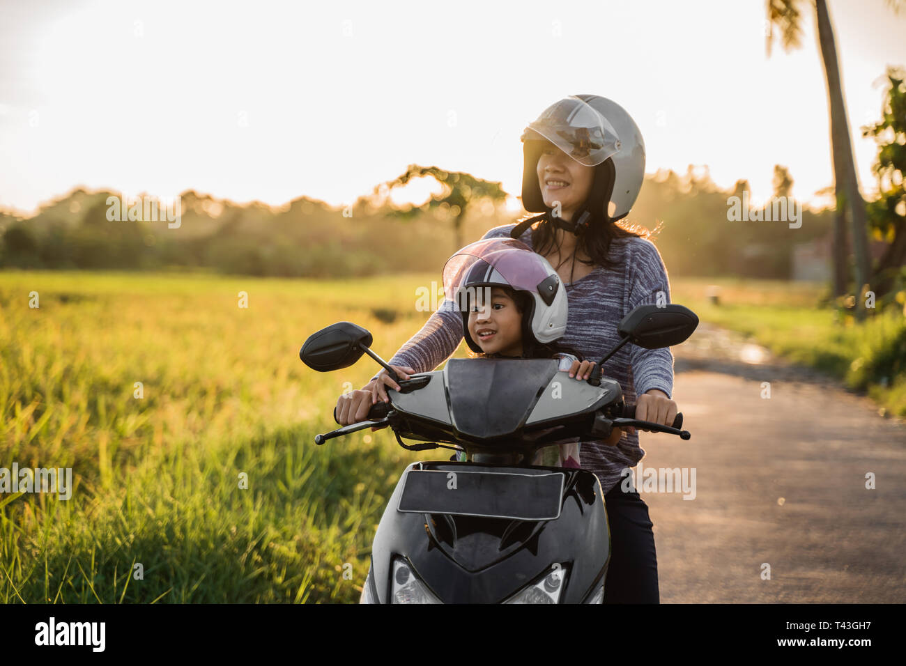 mom and child enjoy riding motorcycle scooter togehter Stock Photo - Alamy