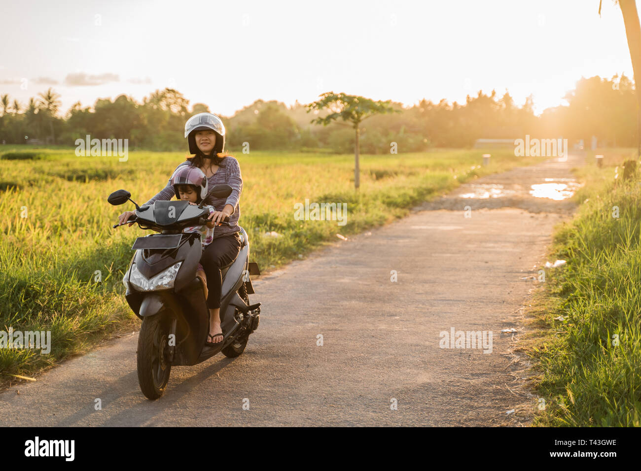 mom and child enjoy riding motorcycle scooter togehter Stock Photo - Alamy