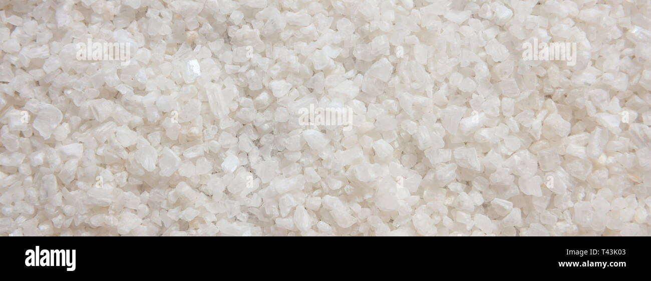 Salt crystals white color full frame background, banner. Close up top ...