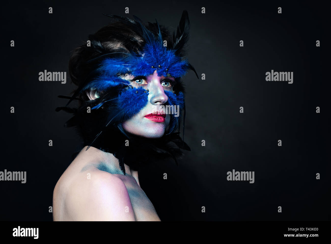 Creative Halloween character. Woman bird makeup on dark background ...