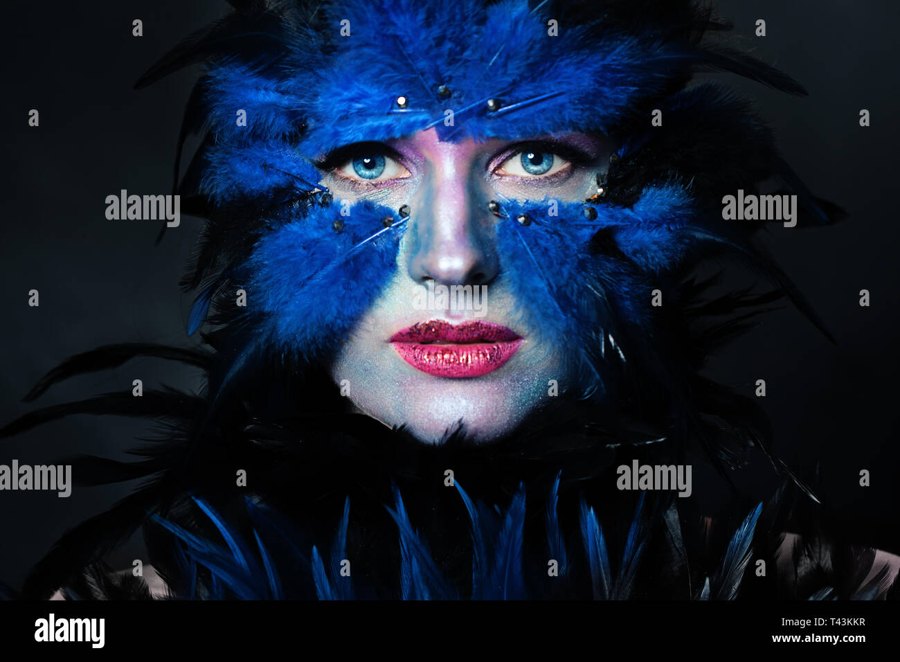 Woman with Halloween makeup. Model face bird character with blue and ...
