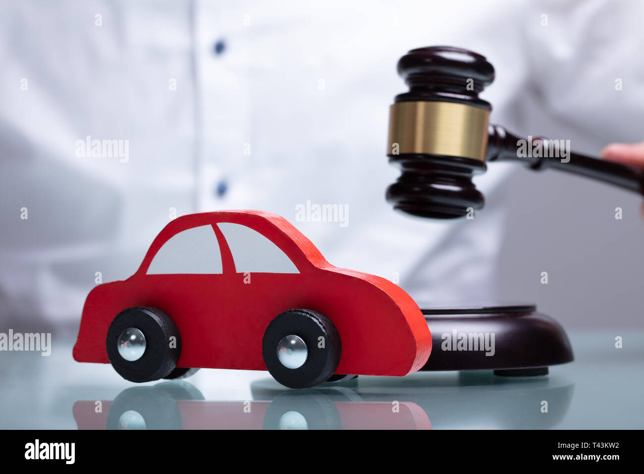 Close-up Of A Small Red Car In Front Of Judge Holding Mallet Stock ...