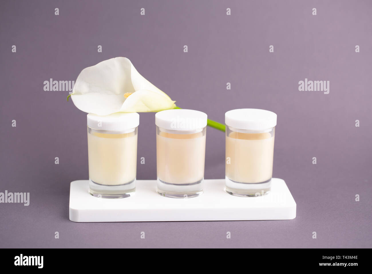 Luxurious cosmetic background. Candle Cream in three jars with white ...