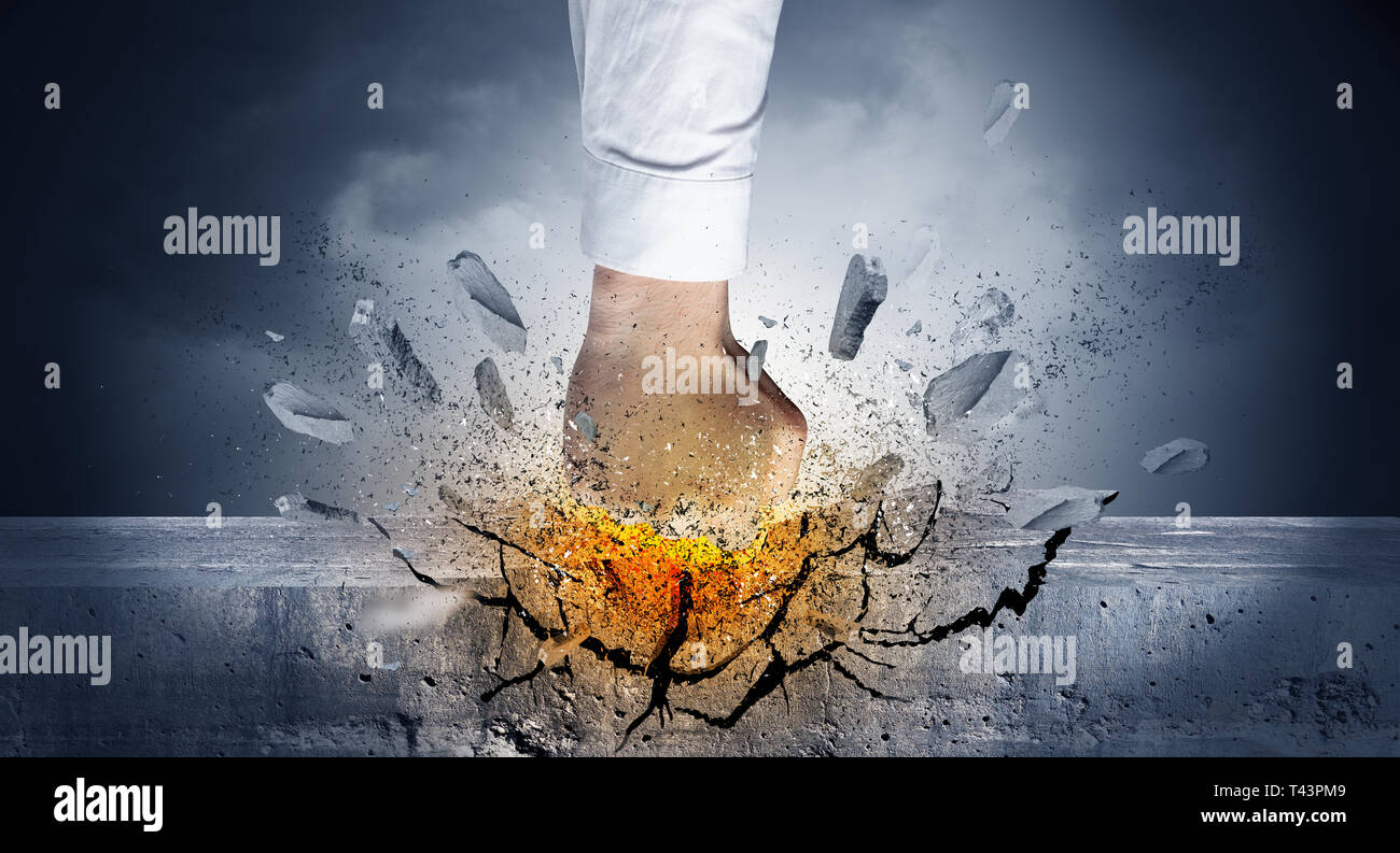 Big hand hits intense and breaks a crass stonewall Stock Photo - Alamy