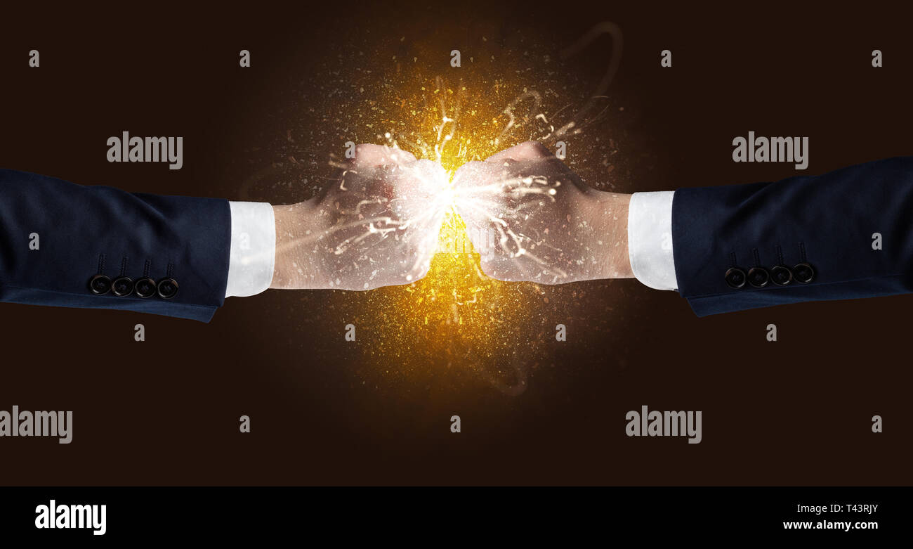 Two hands fighting with orange dust, spark, glow and smoke concept ...
