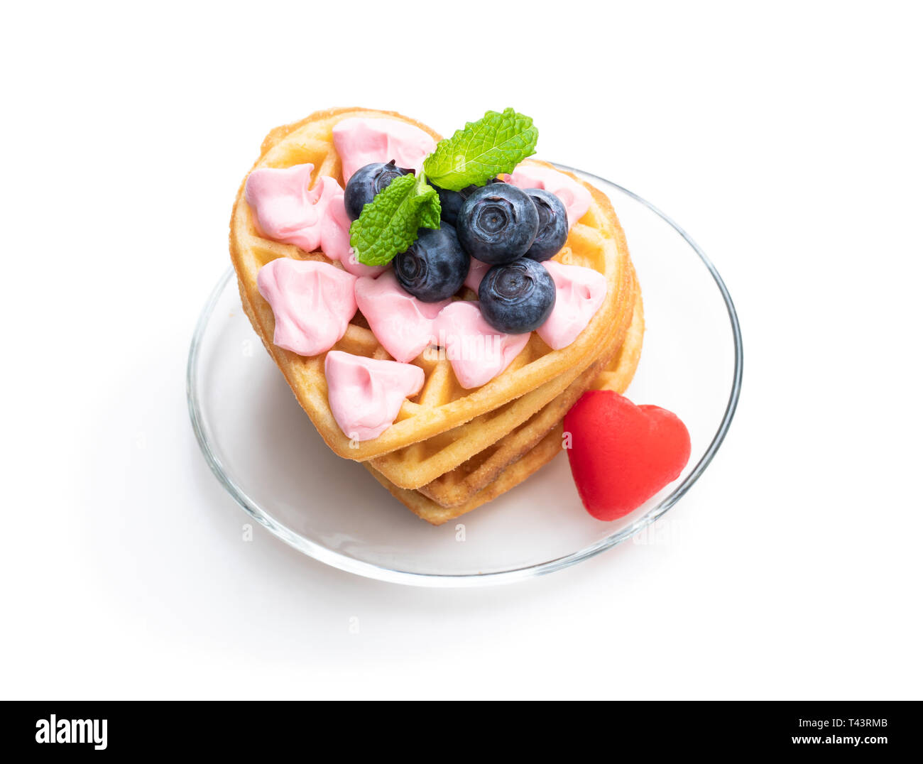 Stack of heart shaped waffles with pink cream and blueberry isolatedon ...