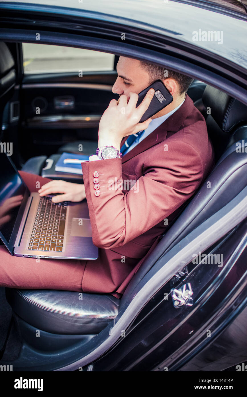 Man in suit is going to a meeting while driving in a limo Stock Photo ...