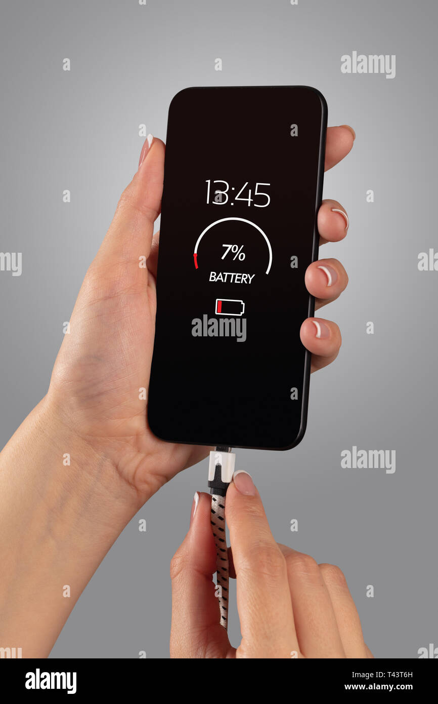 Elegant hand charging cellphone with low battery Stock Photo - Alamy