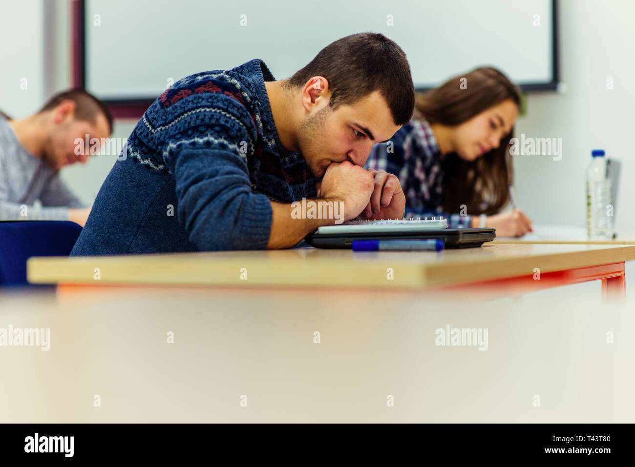 Students sitting in an exam hall doing an exam in university Stock ...