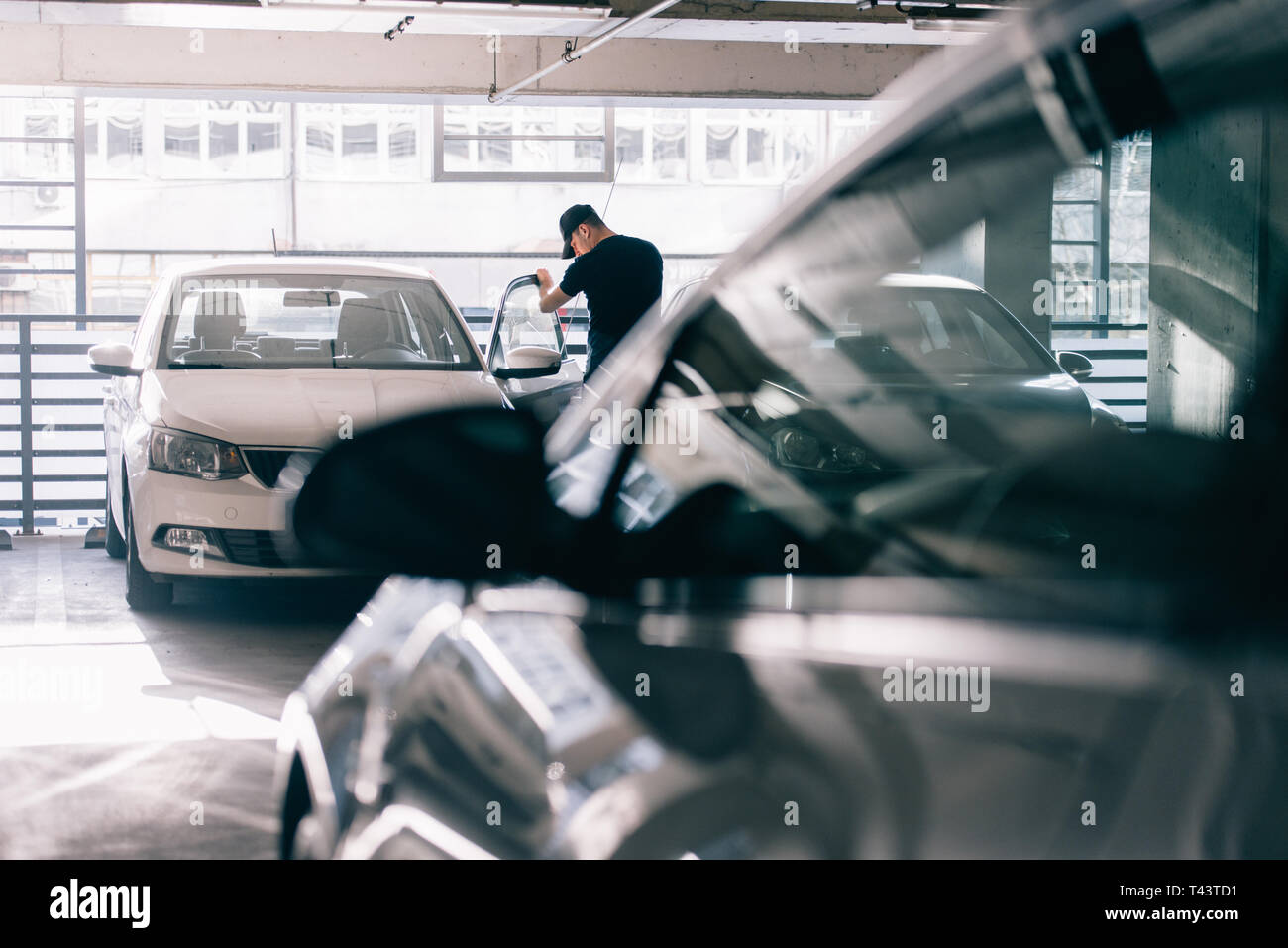 Young thief doing crime while stealing car in garage Stock Photo - Alamy