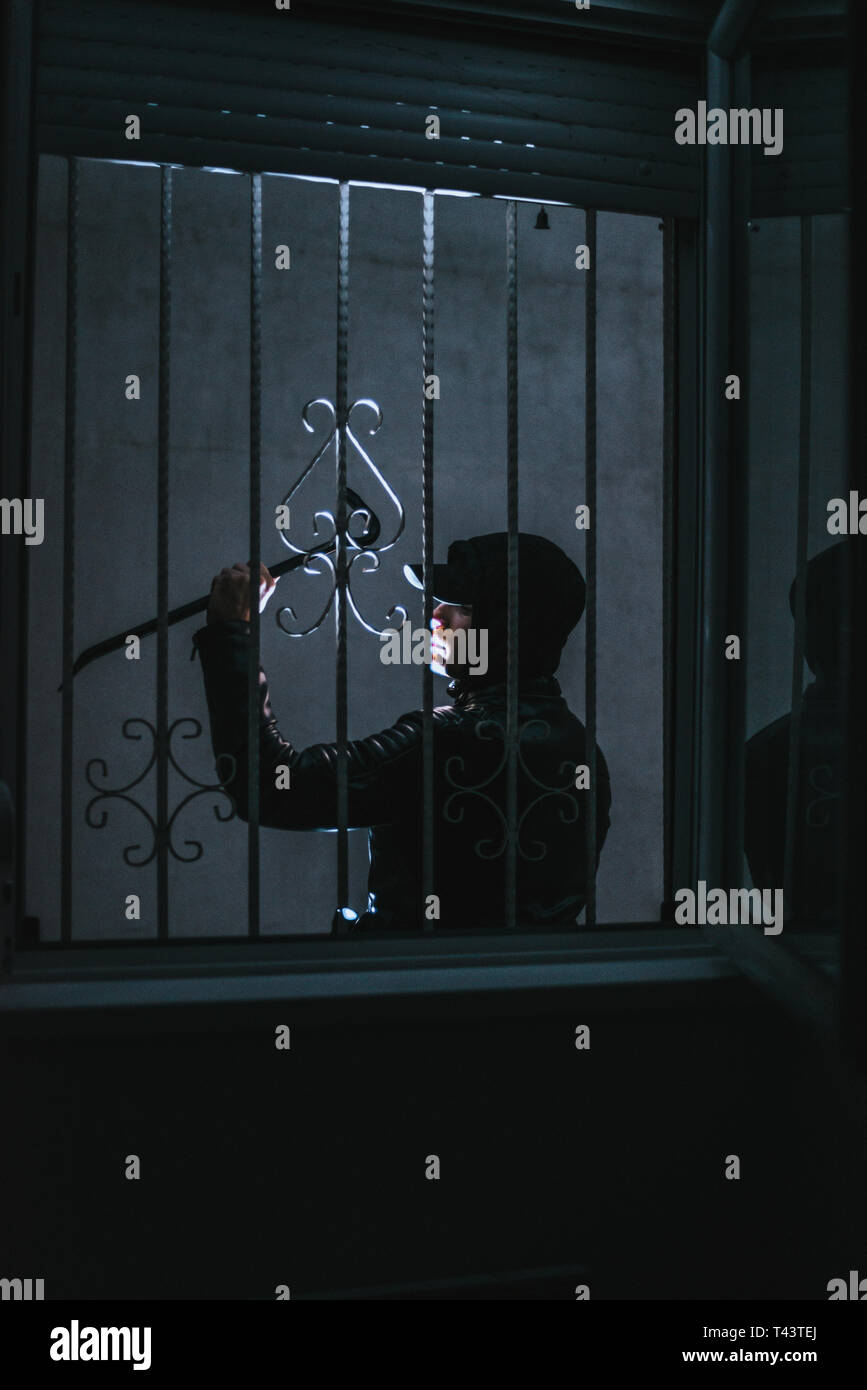 Thief with crowbar breaking and entering into a victim's home Stock ...