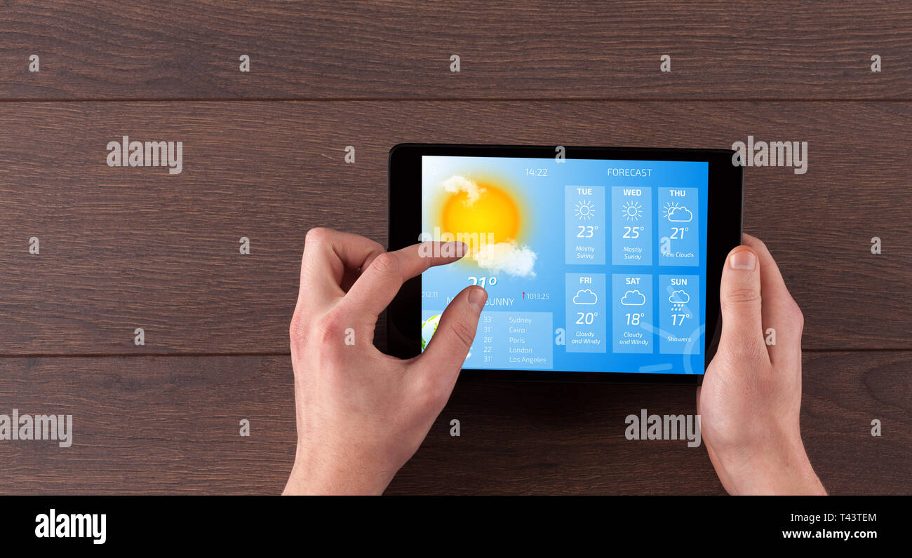Man hand checking weekly weather forecast on tablet Stock Photo - Alamy