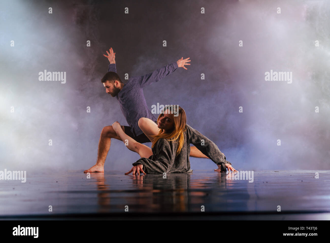 Shoeless dance couple performing multiple unique dance moves in front ...