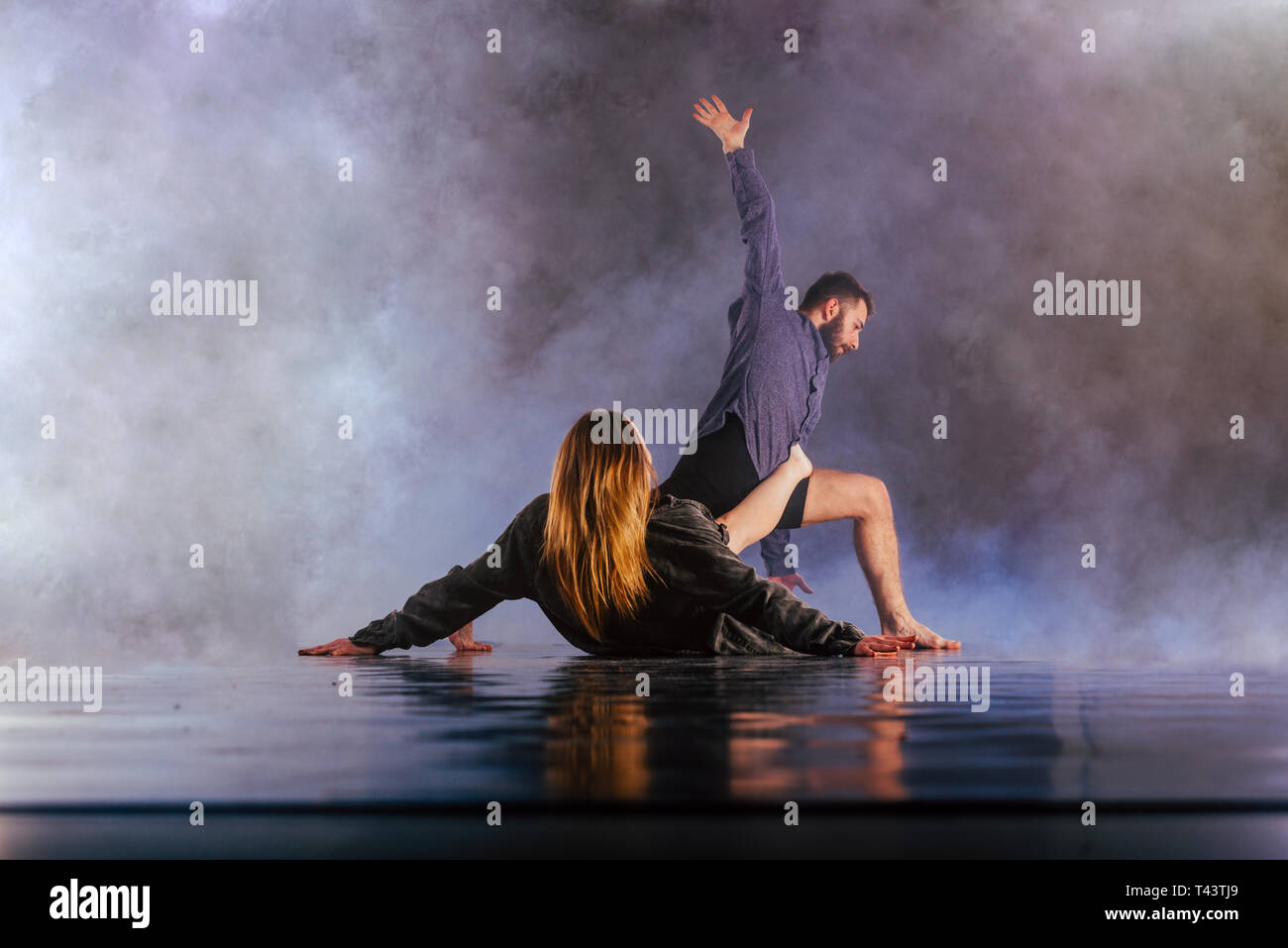 Shoeless dance couple performing multiple unique dance moves in front ...