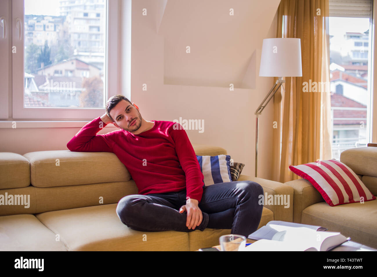 Handsome man college student studying on study table with pile of books ...