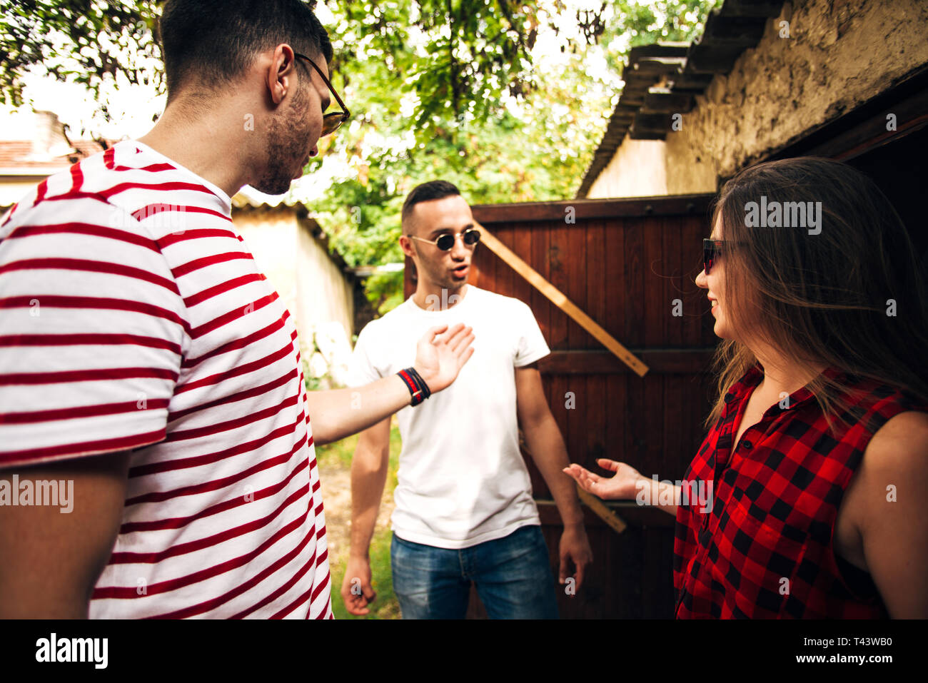 Three young people looking serious having conversation outside Stock ...