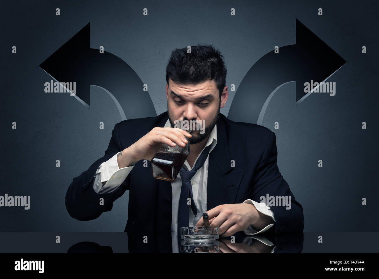 Drunk disappointed man sitting at table with arrows around Stock Photo ...