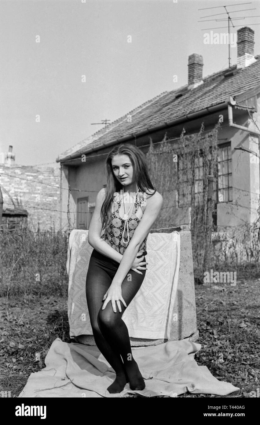 slim pretty young female standing in garden of traditional hungarian ...