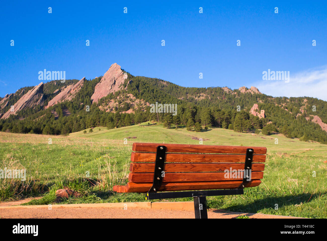 Wood park bench with view of the Flatirons in Boulder Colorado from ...
