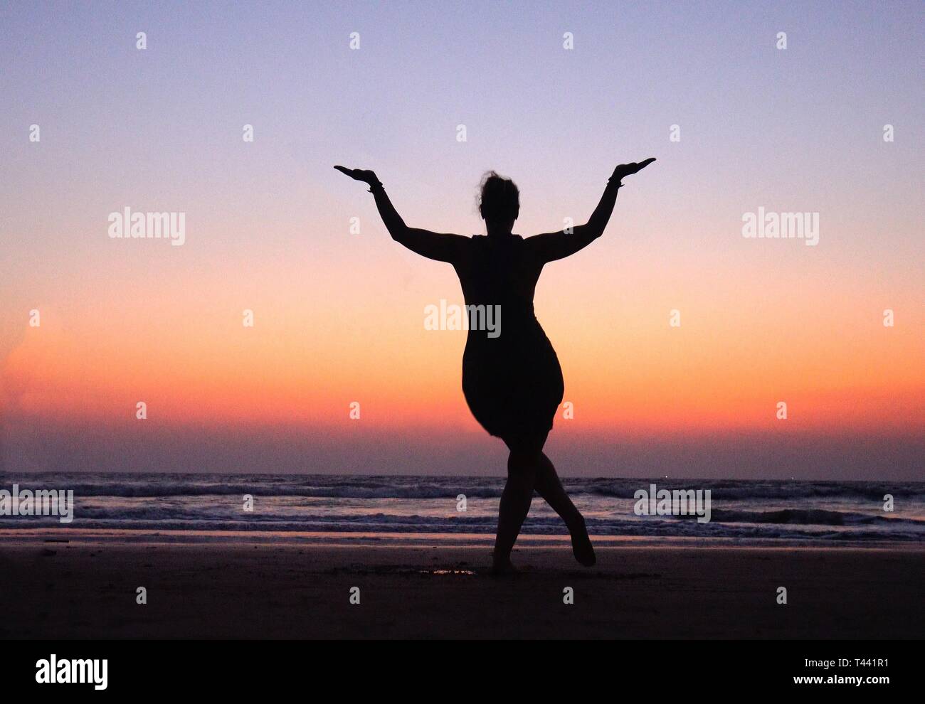 Woman in Pose dancing Shiva in Sunset pink Sky near sea in India. Dance ...
