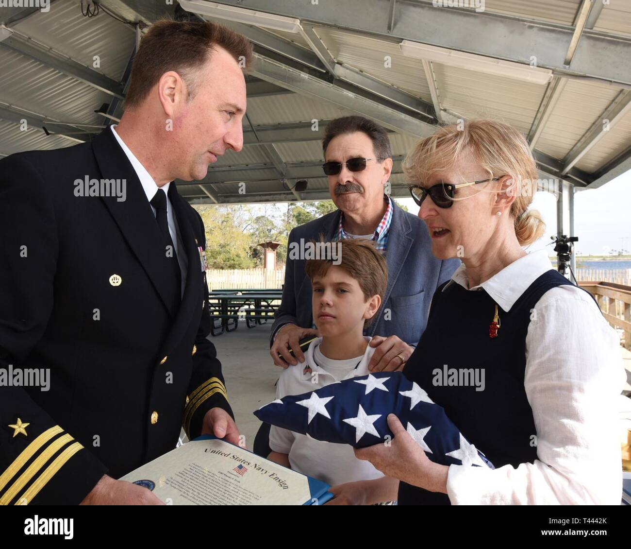 Panama City, FL -- Nicole Ervin Parker accepts the Navy Ensign from ...