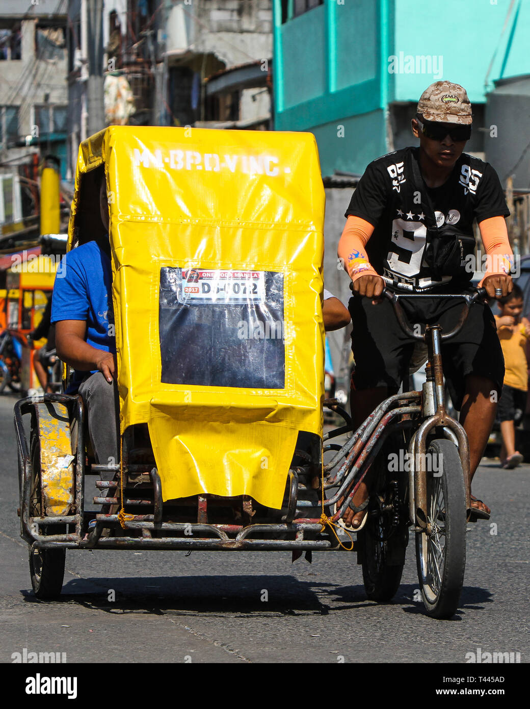 A local transport pedicab (rickshaw) driver with his passenger traverse ...