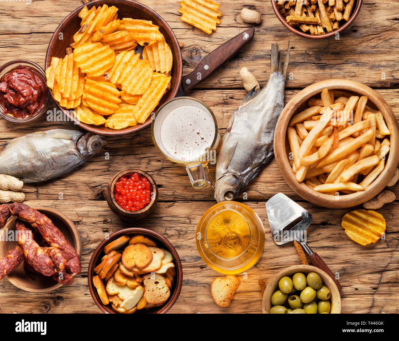 Selection of beer and snacks.Chips, fish, beer sausages on the table ...
