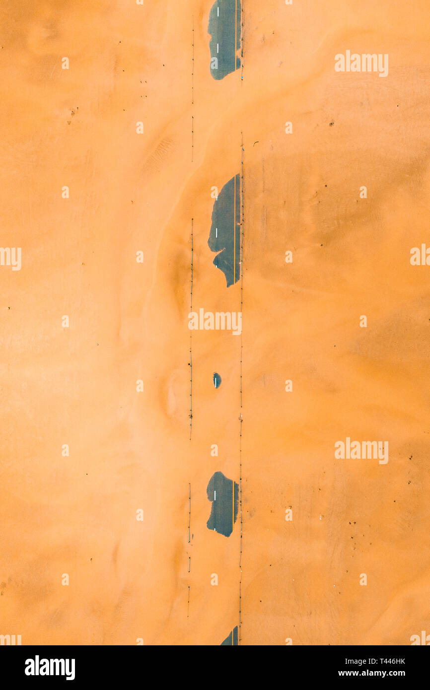 View from above, stunning aerial view of a road covered by sand dunes ...