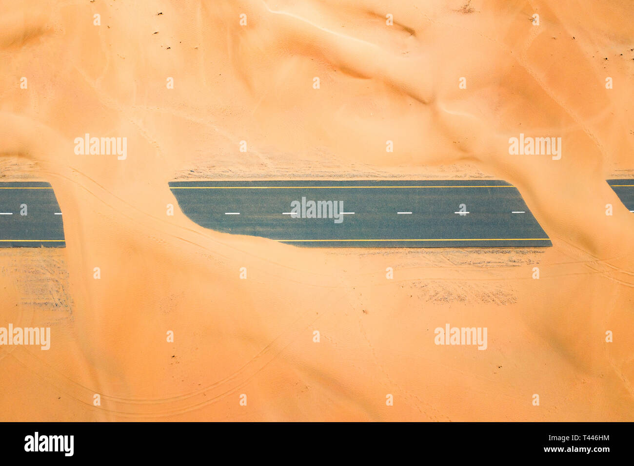 View from above, stunning aerial view of a road covered by sand dunes ...