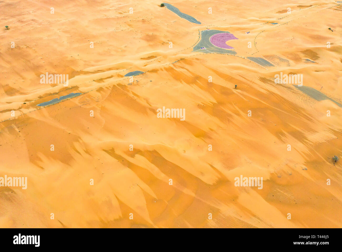 View from above, stunning aerial view of a road covered by sand dunes ...