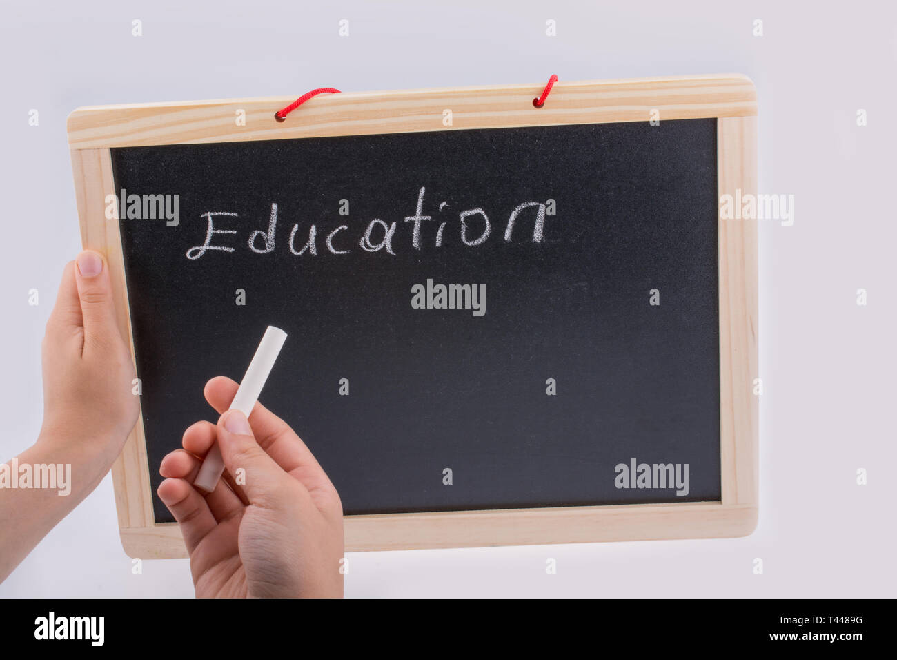Hand holding a blackboard with 'education' written on it on a white ...