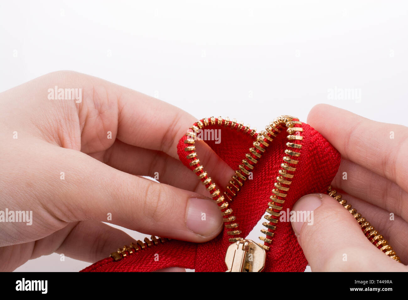 Hand holding color zipper on a white background Stock Photo - Alamy