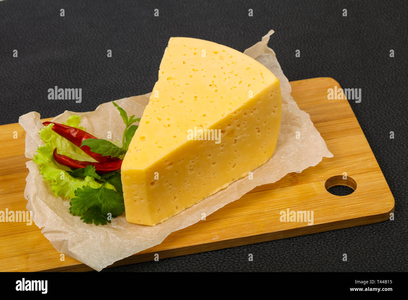 Piece. of Yellow Cheese served herbs Stock Photo - Alamy