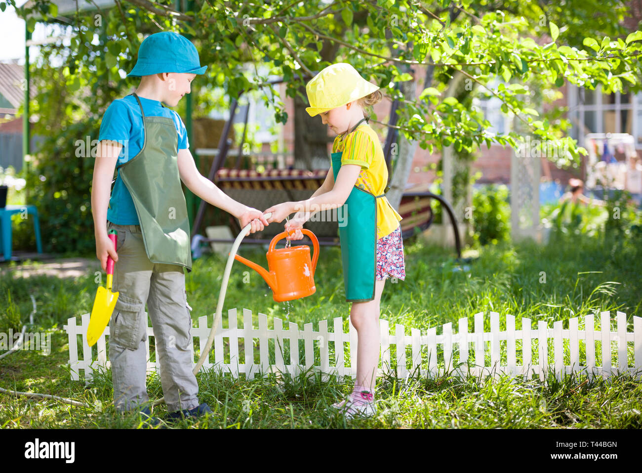 Children watering new plant hi-res stock photography and images - Alamy