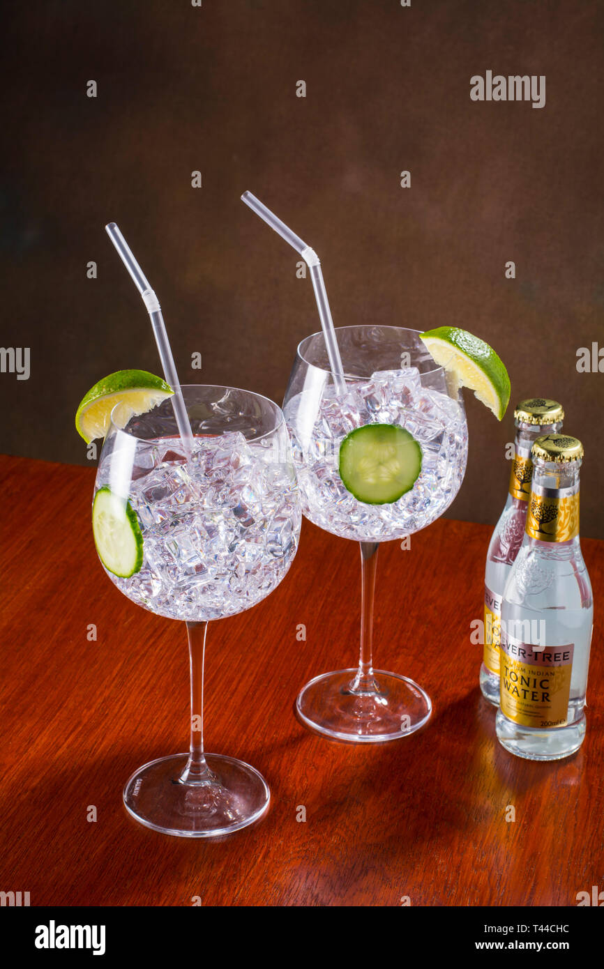 Gin and tonic, modern style - globe glass, lots of ice, slices of ...