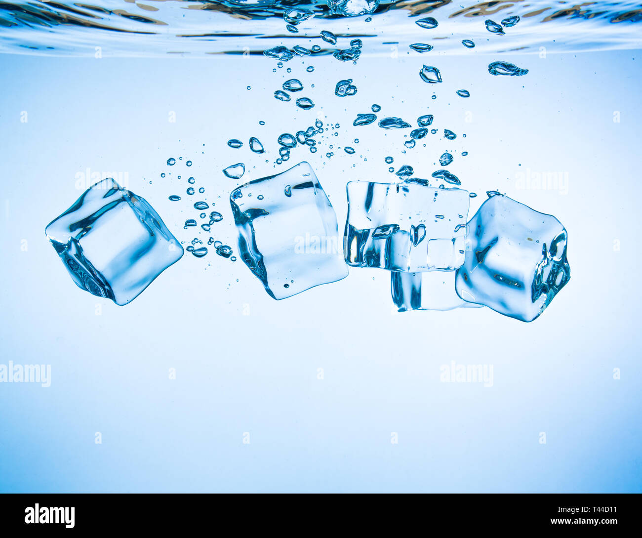 Ice cubes falling into the water sinking to the bottom. Abstract ...