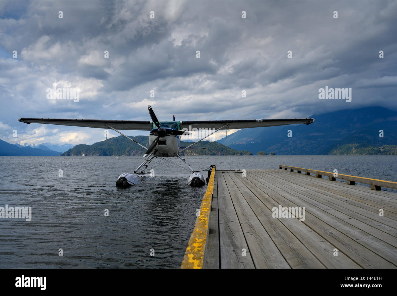 Hydroplane tied to the water aerodrome on Harrison Lake over blue and ...