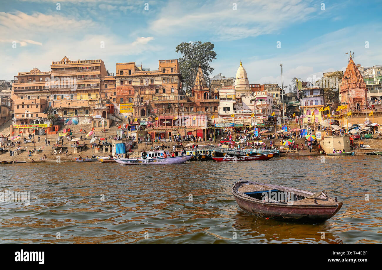 Ancient Varanasi city architecture with view of a wooden boat on river ...