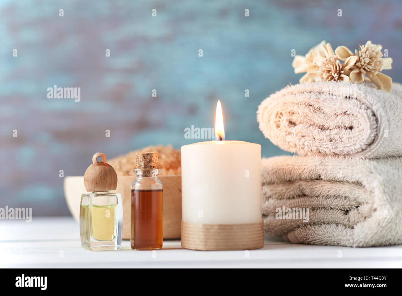 Spa and relax composition with massage oil, towels and burning candle ...